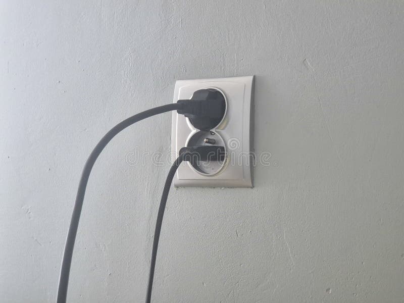 Close-up of a Power Outlet with Two Connected Cables Against a Plain ...