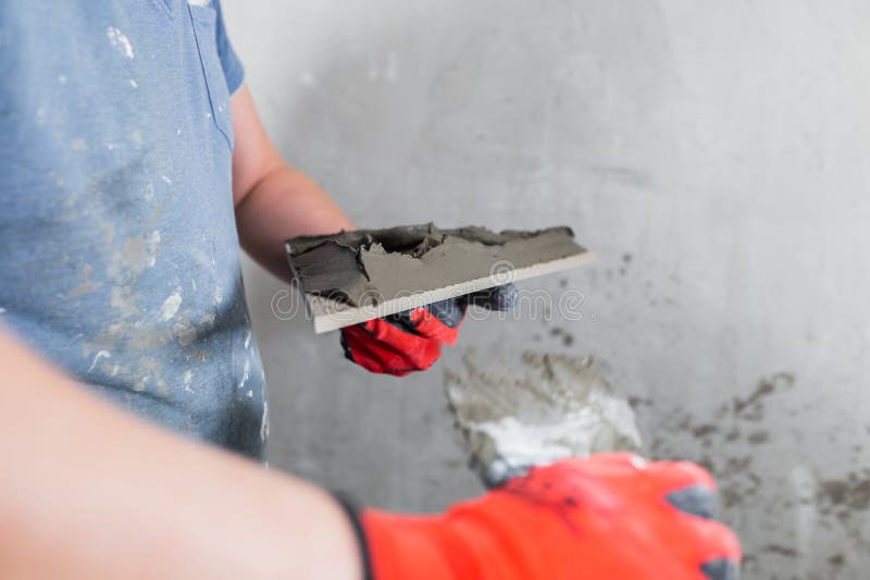 Close-up of the Process of Installing Tiles on the Floor and Wall Stock ...