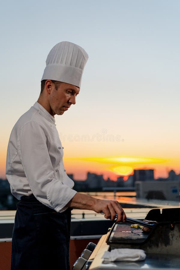 Close-up of a Professional Chef Cooking Bbq on a Rooftop at Sunset ...