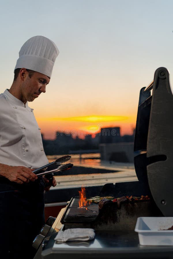 Close-up of a Professional Chef Cooking Bbq on a Rooftop at Sunset ...