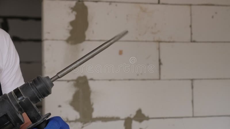 Close-up of a Construction Worker Picking Up a Hammer Drill and Turning ...