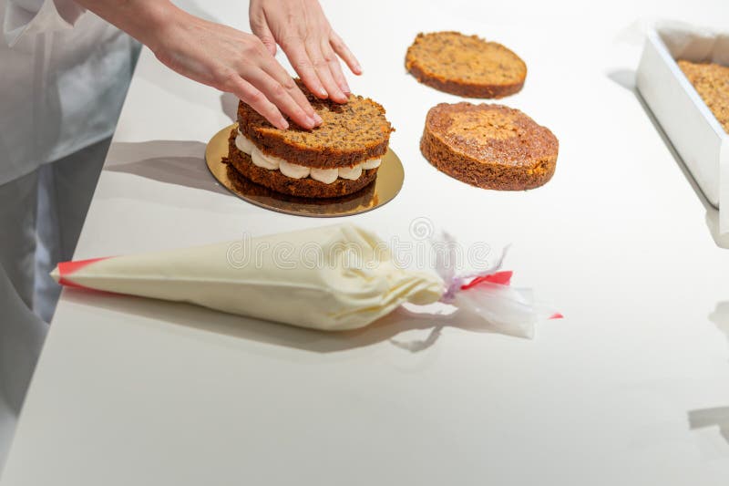 Close-up of a Professional Pastry Chef Assembling a Cake Filled with ...