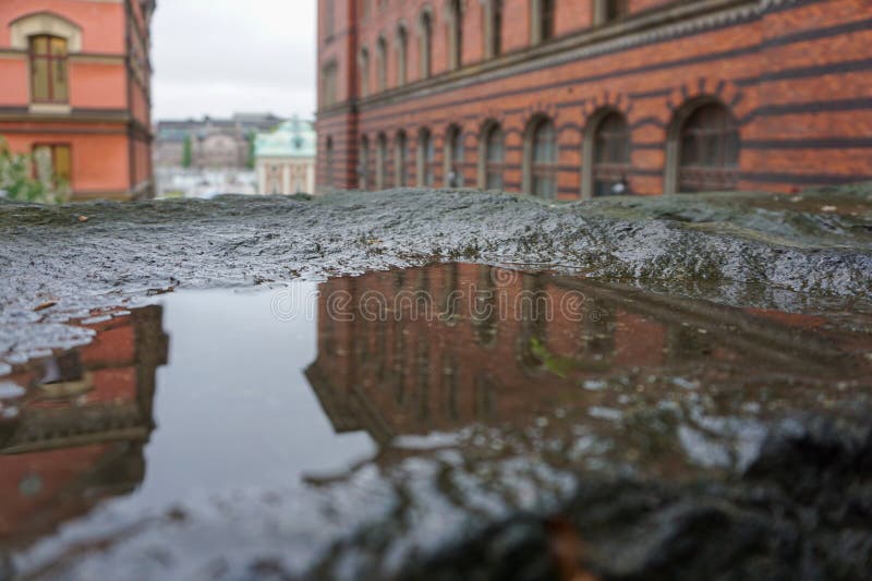 Close Up of a Puddle in Front of Buildings Stock Image - Image of wall ...