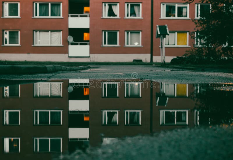 Close Up of a Puddle of Water in Front of Apartment Building during the ...