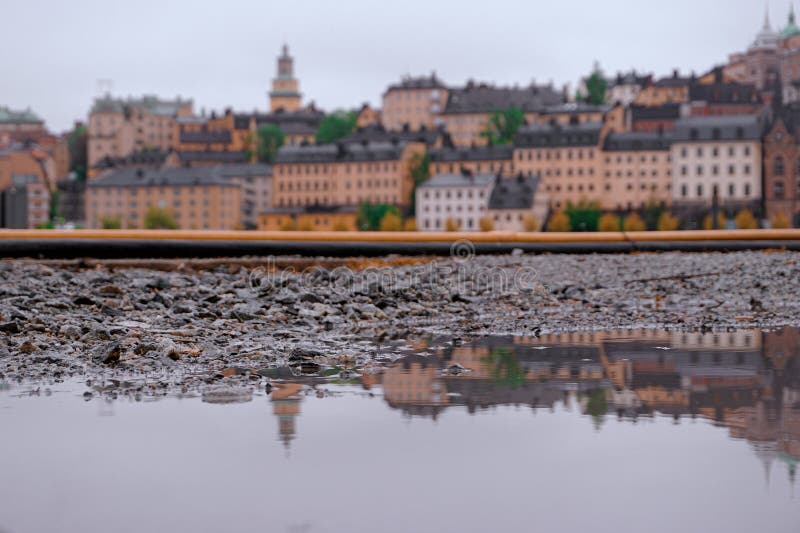 Close Up of a Puddle of Water in Front of a Cityscape Stock Photo ...