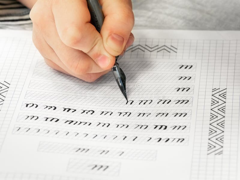 Close-up Pupil`s Hands are Writing Calligraphy in a Notebook. Schoolboy ...