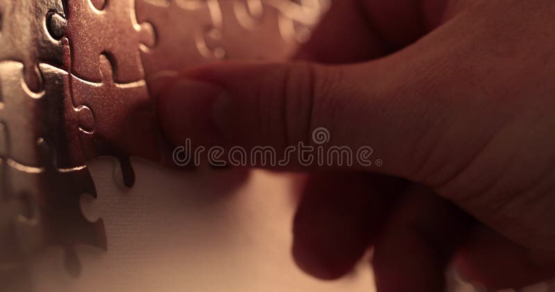 Close-up of the Puzzle. a Hand that Puts a Part of the Puzzle Stock ...