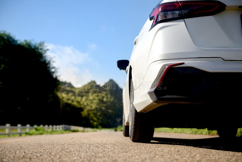 Close-up Rear View of a White Car with Mountains and Sky on the Road ...