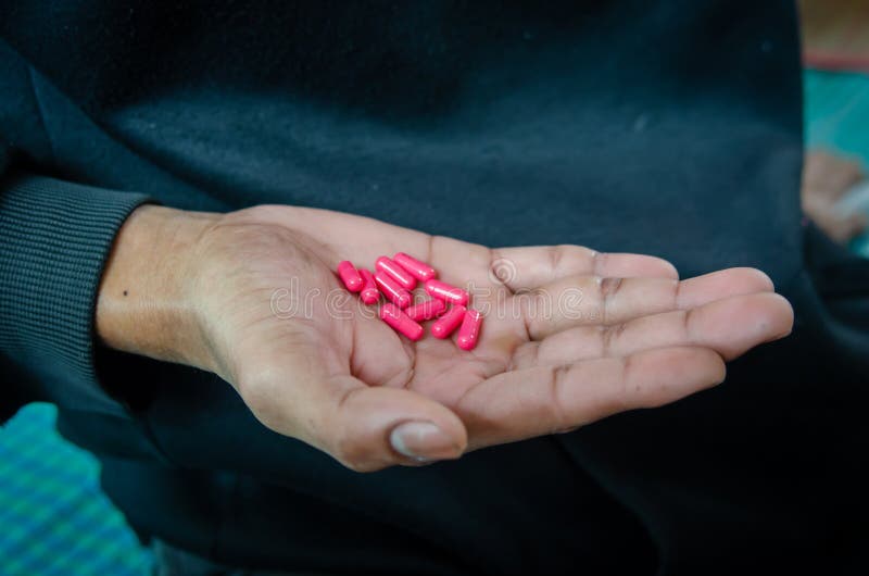 Red capsule on hand stock photo. Image of horizontal - 202593218