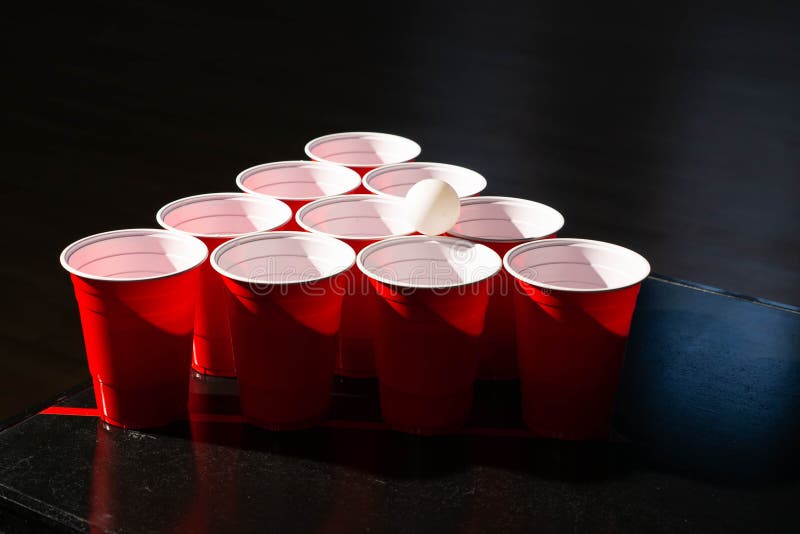 Close Up Red Plastic Beer Pong Cups With White Ball On Top Of Beer Pong