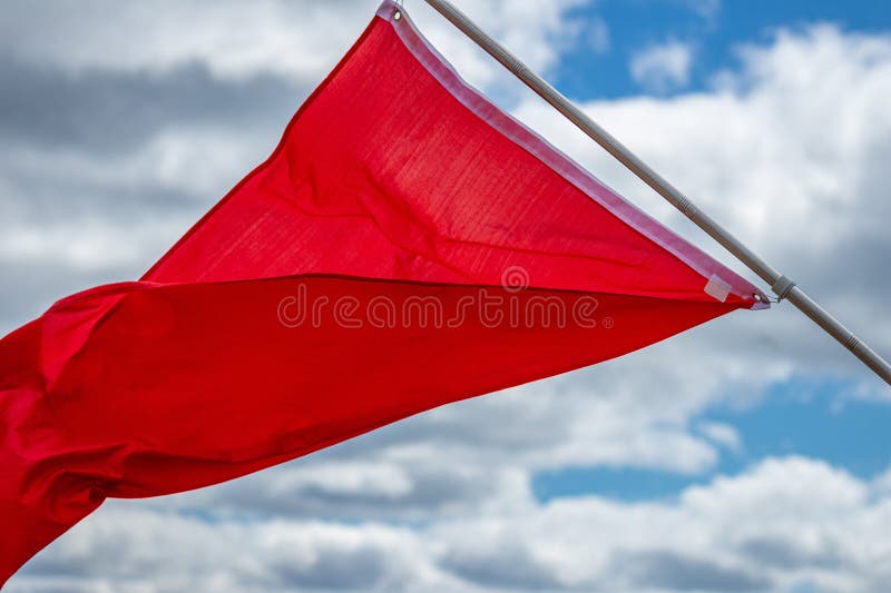Close Up of a Red Warning Flag Flying in the Wind Stock Image - Image ...