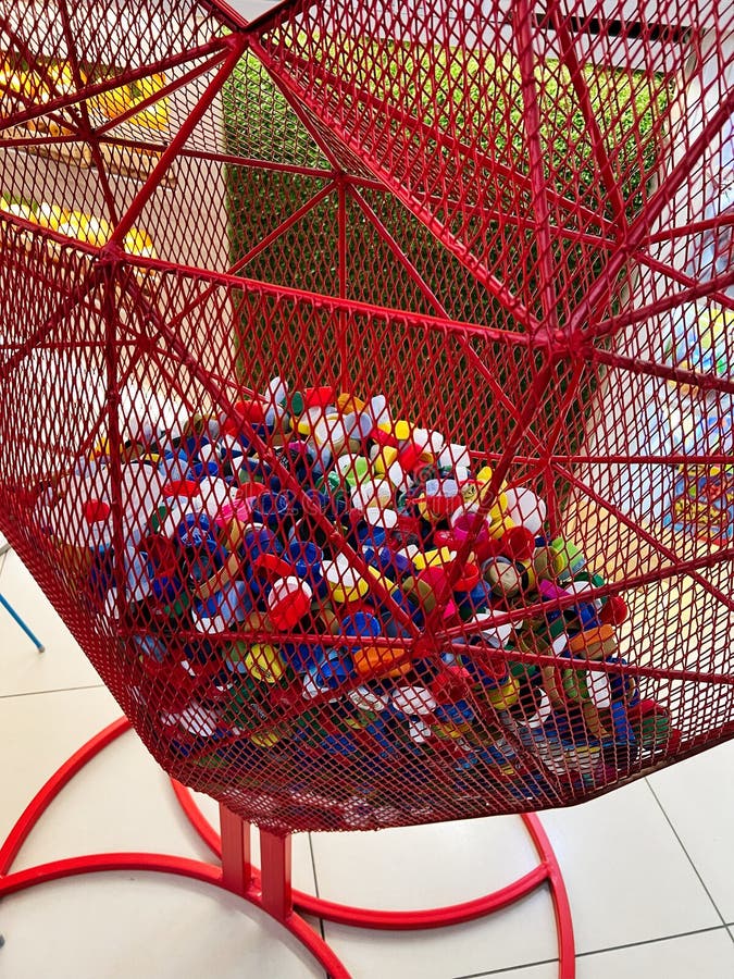 Red Metal Container Holding Colorful Plastic Bottle Caps in a Geometric ...