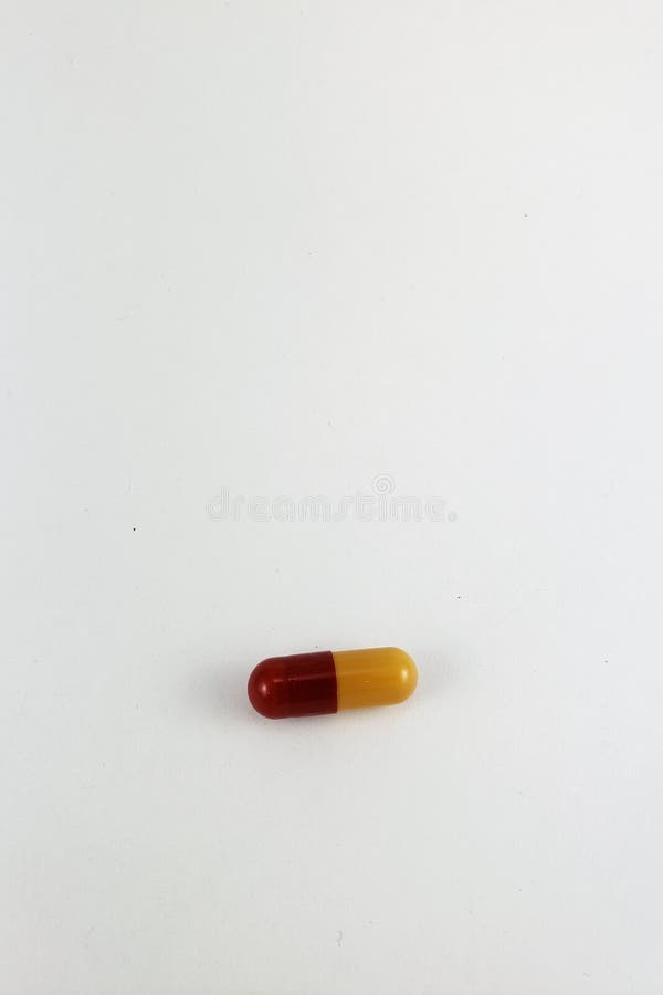 A Close Up of a Red and Yellow Pill in Front of a White Background ...
