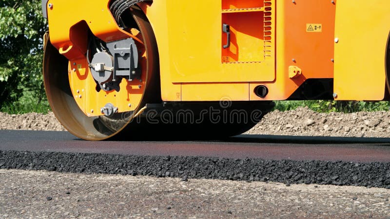 Close-up, Road Construction Works with Roller Compactor Machine and ... Close-up, Road Construction Works with Roller Compactor Machine and ...