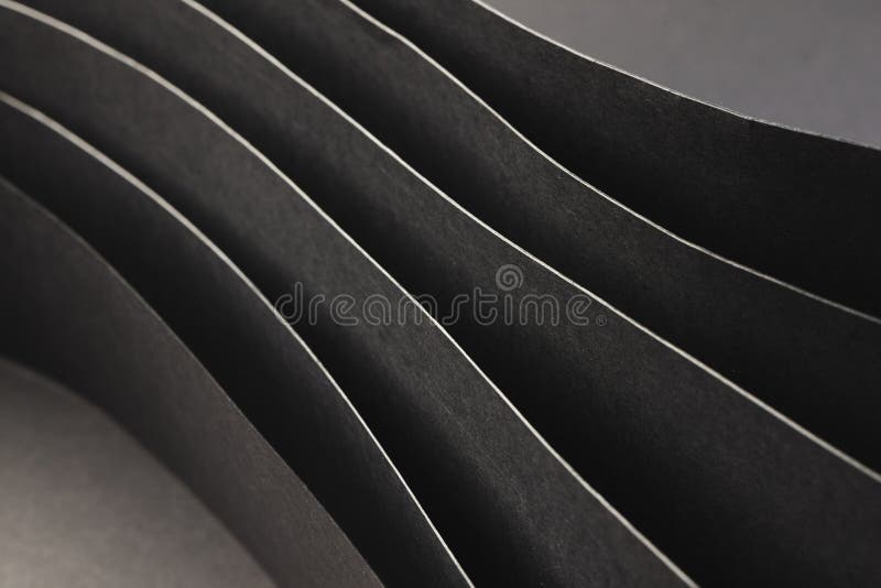 Close Up of Rolled Up Pieces of Black Paper with Copy Space on Grey ...