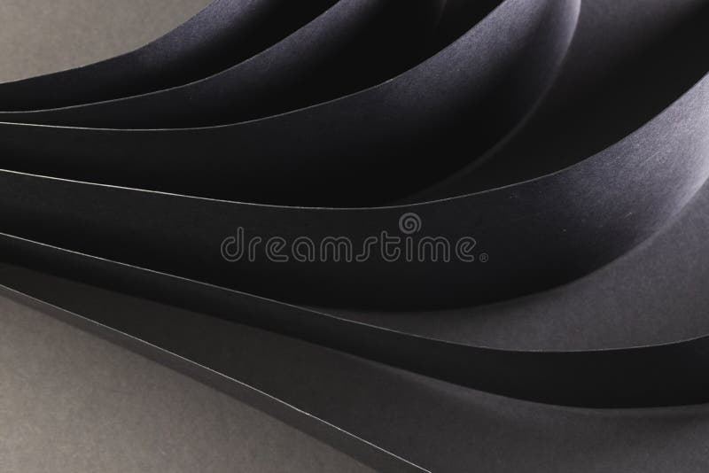 Close Up of Rolled Up Pieces of Black Paper with Copy Space on Grey ...