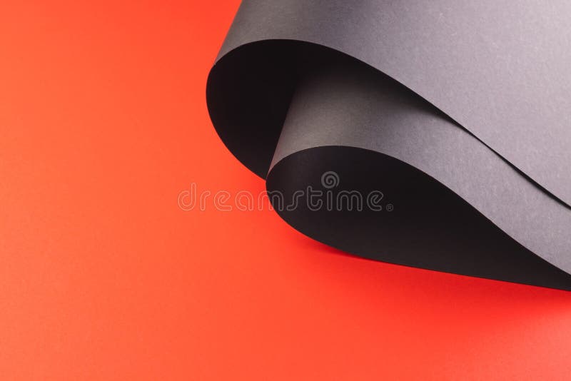 Close Up of Rolled Up Pieces of Black Paper with Copy Space on Red ...