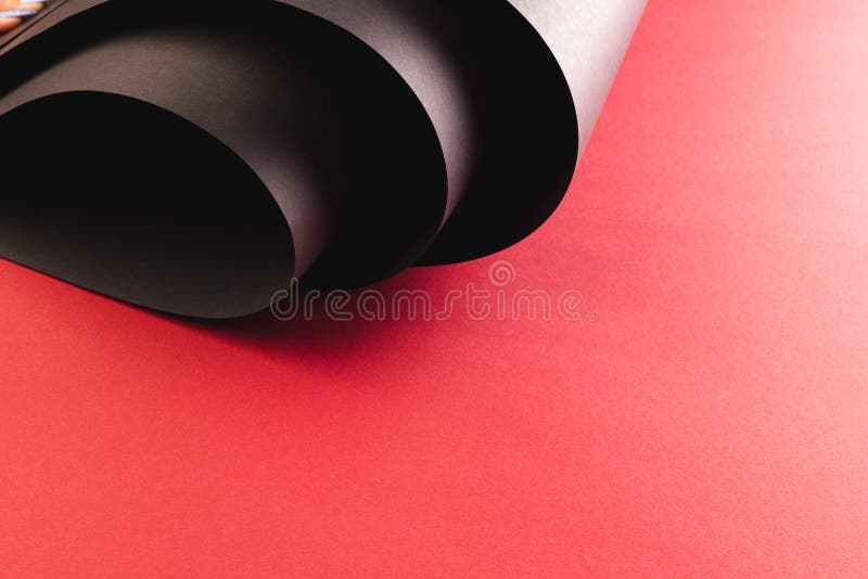 Close Up of Rolled Up Pieces of Black Paper with Copy Space on Red ...