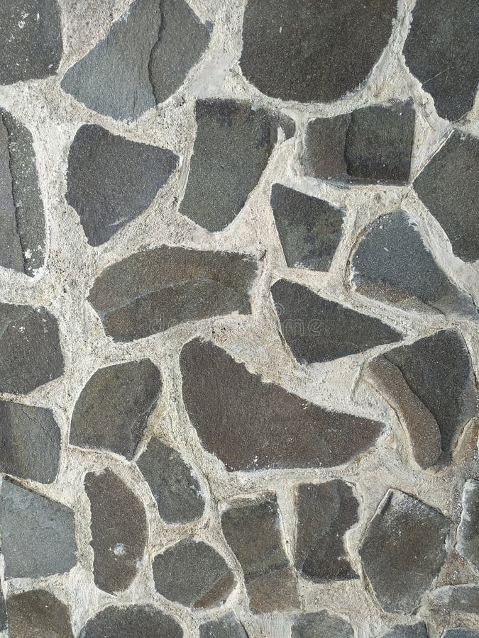 A Close-up of a Rustic Wall Featuring Irregular River Stones Set in ...