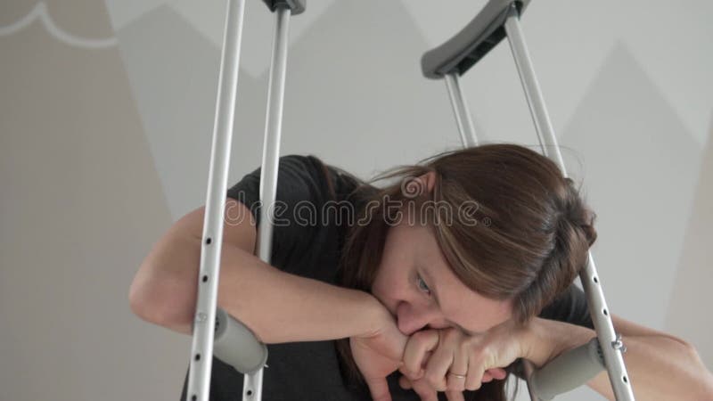A Sad Woman Sits Leaning on Crutches. Stock Video - Video of woman ...