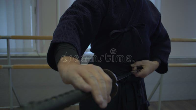 Close-up, the Samurai`s Hands Slowly Insert into the Katana`s Sword ...