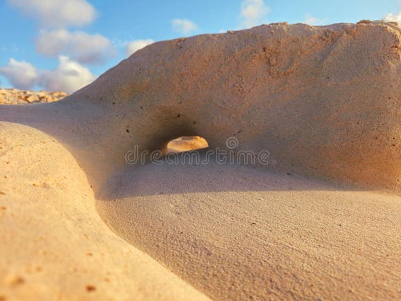 Close-up of a Sand Formation on the Beach with a Tunnel. a Cloudscape ...
