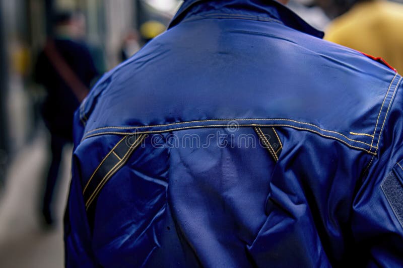 Close-up of a Security Guard Uniform with Blue Jacket and Yellow Text ...