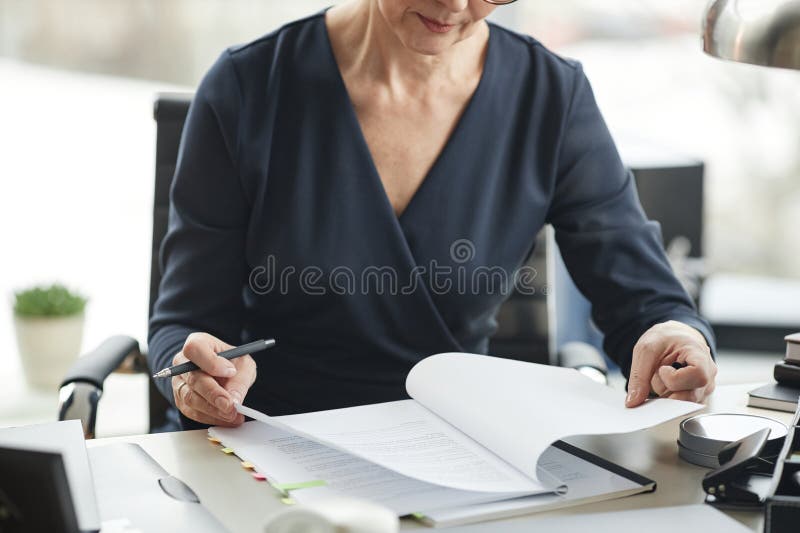 Close Up of Senior Female Boss Working with Documents at Desk in Office ...