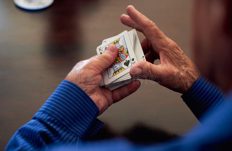 Close Up of Senior Man at Home Sitting at Table Shuffling Deck and ...