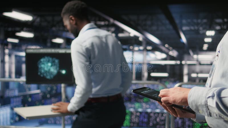 Close Up of Server Room Worker Checking Code on Tablet Next To ...