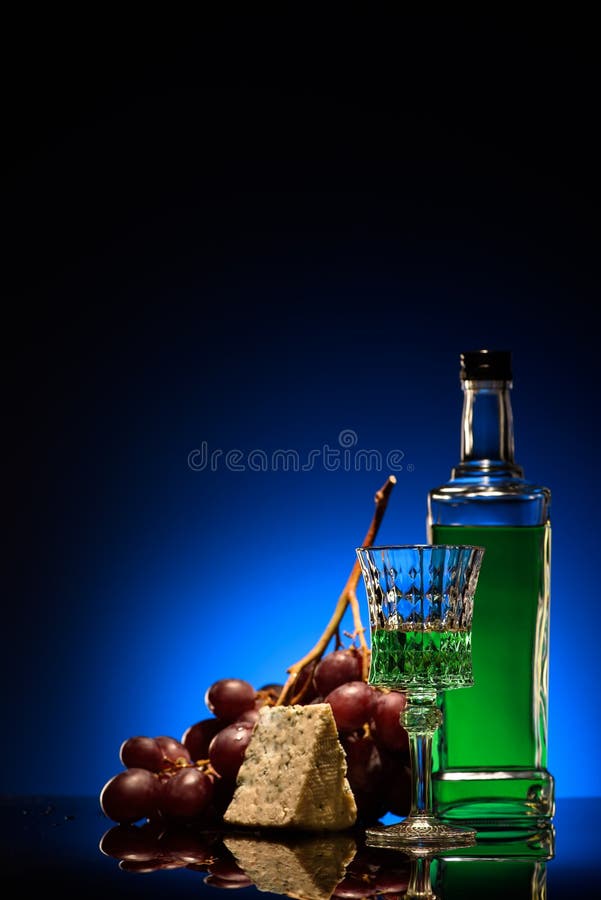 Close-up Shot of Absinthe with Grapes and Dorblu Cheese on Mirror ...