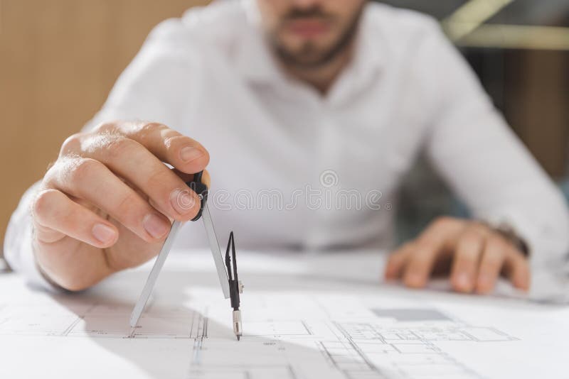 Close-up Shot of Architect with Compass Working on Building Plans Stock ...