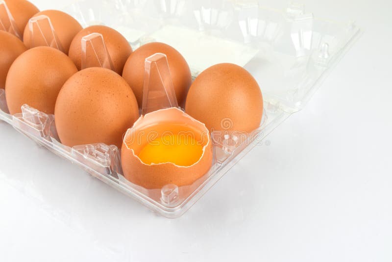 A Close Up Shot of a Broken Egg in an Egg Box on a White Wooden Floor ...