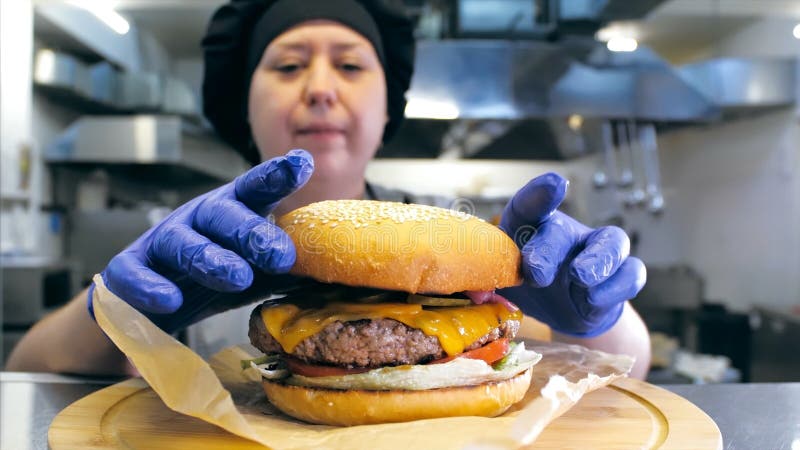 Close-up Shot of Chef`s Hands Preparing a Delicious Burger with Cheese ...