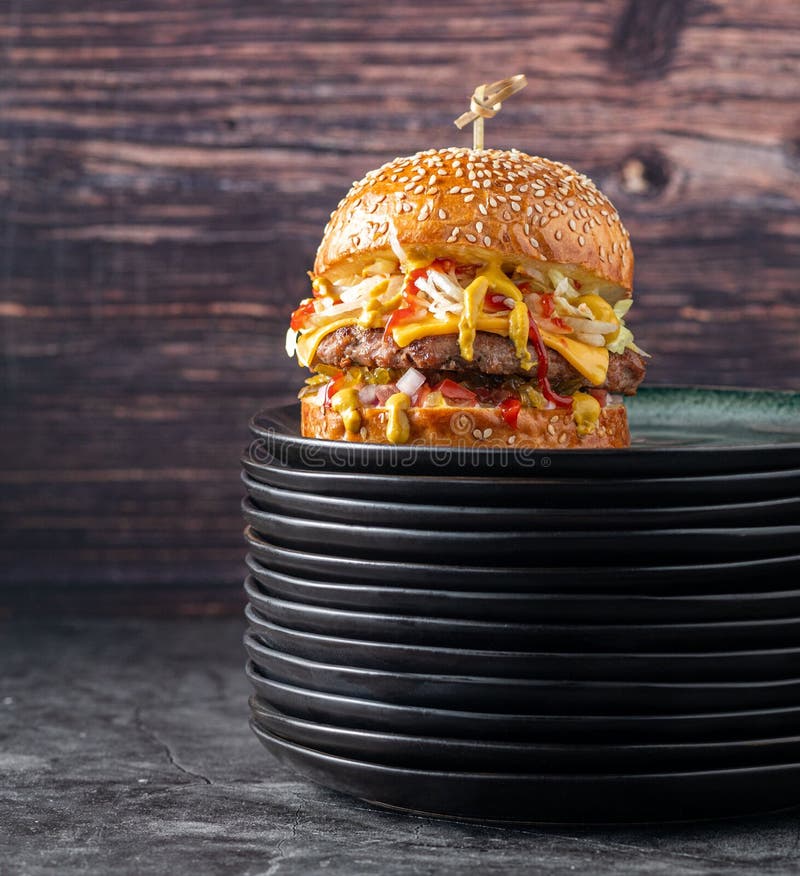 Close-up Shot of a Juicy Burger Placed on a Several Plates Stock Photo ...