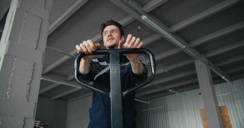 Close-up Shot of a Man in a Special Blue Uniform Pulling a Load by the ...