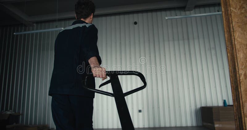 Close-up Shot of a Man in a Special Blue Uniform Pulling a Load in a ...
