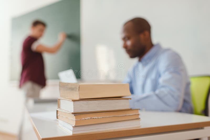 Close Up Shot of Stack of Books with Teacher and High School Student ...
