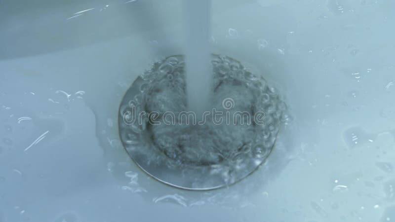 Close Up Shot Video Of Water Flowing Down A Stainless Steel Bathroom