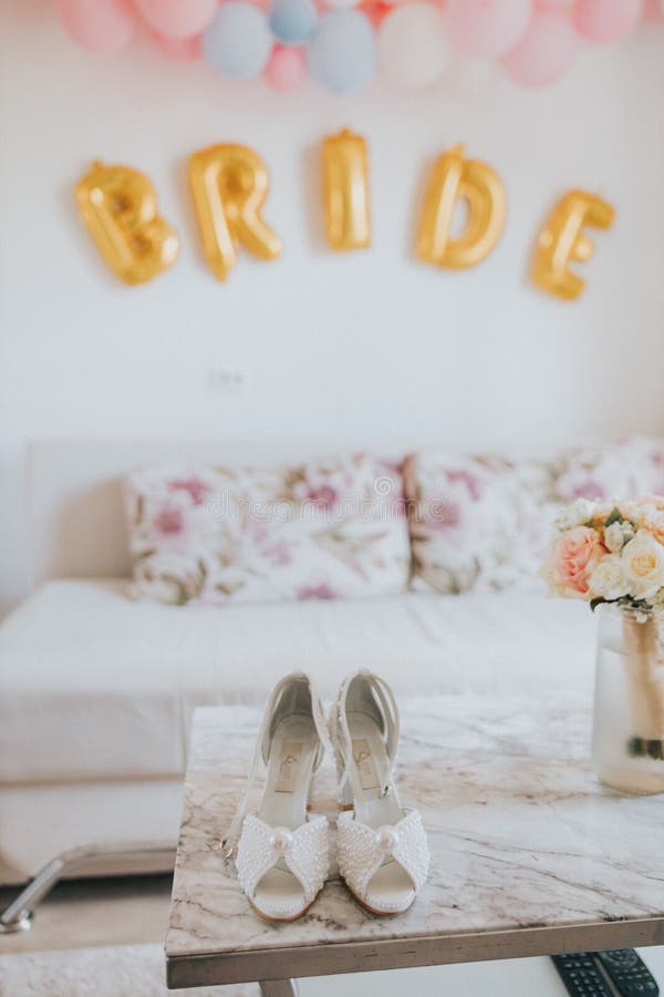 Close-up Shot of the White Heels of the Bride on the Marble Table ...