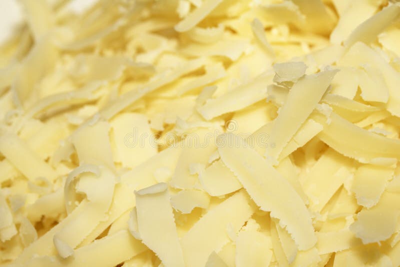 Close Up of Grated Cheddar Cheese Falling and Piling Up on White ...