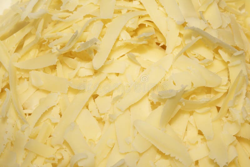 Close Up of Grated Cheddar Cheese Falling and Piling Up on White ...