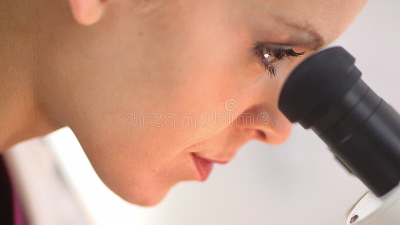 Close Up Side View of Medical Researcher Looking into Microscope Stock ...