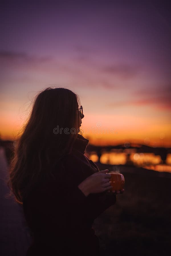 Close-up. Silhouette of a Girl Drinking Tea from a Cup and Watching the ...