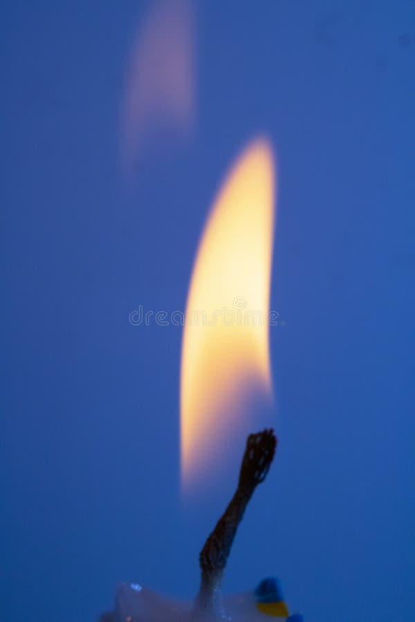 A Close Up of a Single Candle Flame and Wick on Coloured Background ...