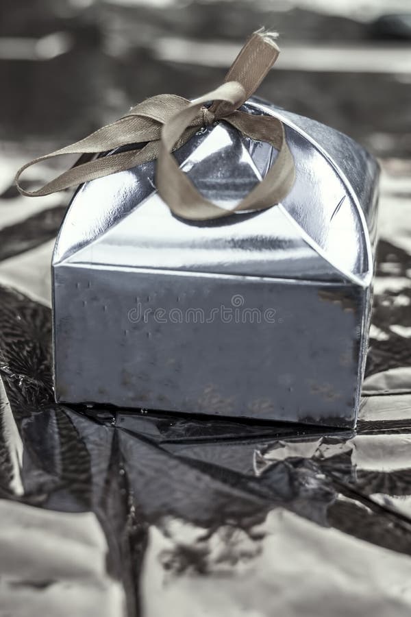 Close Up of a Small Gift Box Cover with Silver Shiny Paper on Brownish ...