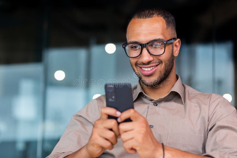 Close-up of Smiling African-American Businessman Using Phone Typing ... Close-up of Smiling African-American Businessman Using Phone Typing ...