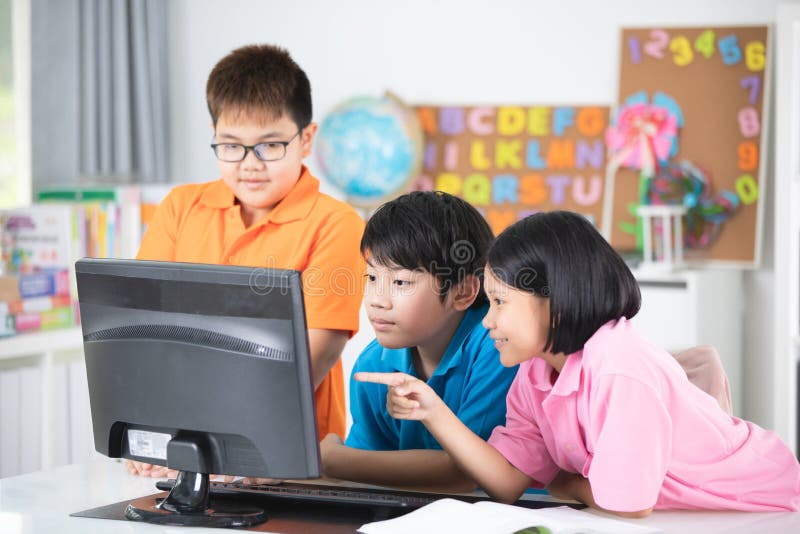 Close Up of Smiling Asian Pupils Using a Desktop Computer. Stock Image ...