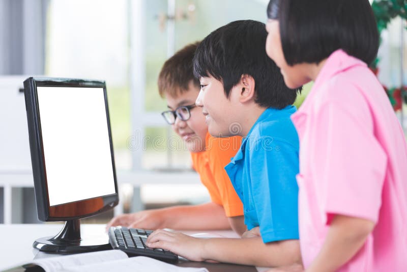 Close Up of Smiling Asian Pupils Using a Desktop Computer. Stock Image ...
