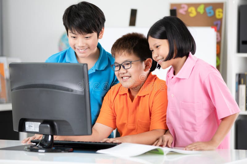 Close Up of Smiling Asian Pupils Using a Desktop Computer. Stock Photo ...